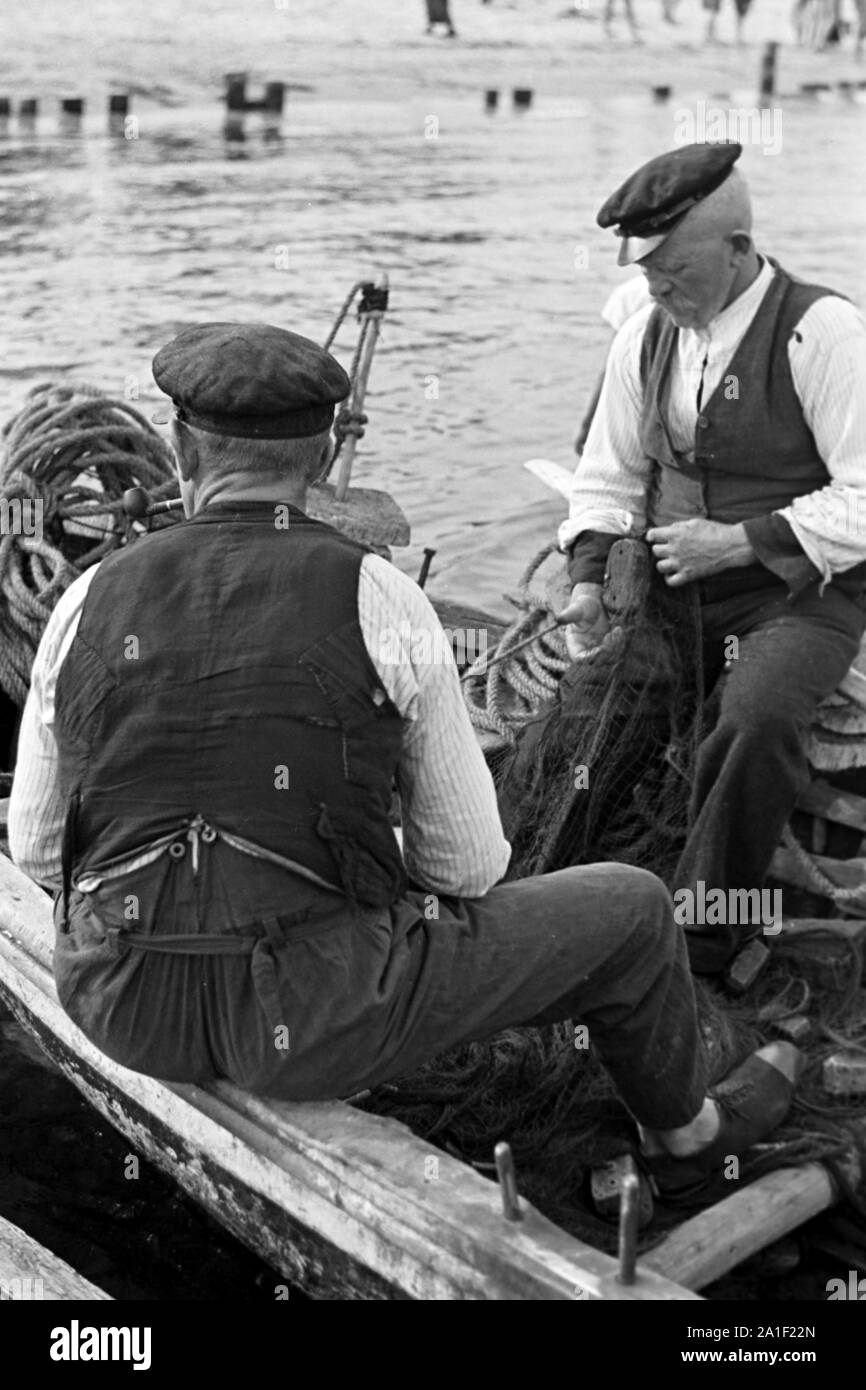 Fischer sortieren ihre Netze bevor sie sie zum Fischfang ins Meer ...