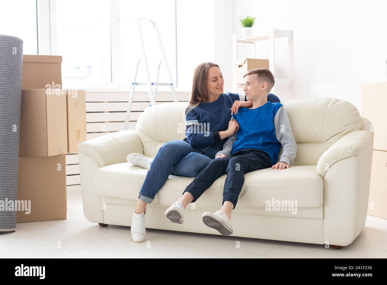 Cute single mom and little boy son relaxing after the move. The concept ...