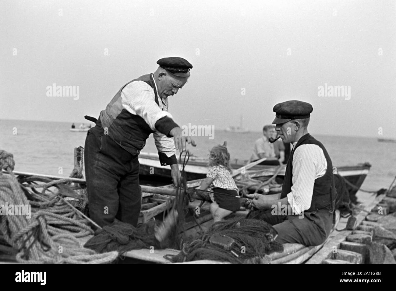 Fischer sortieren ihre Netze bevor sie sie zum Fischfang ins Meer ...