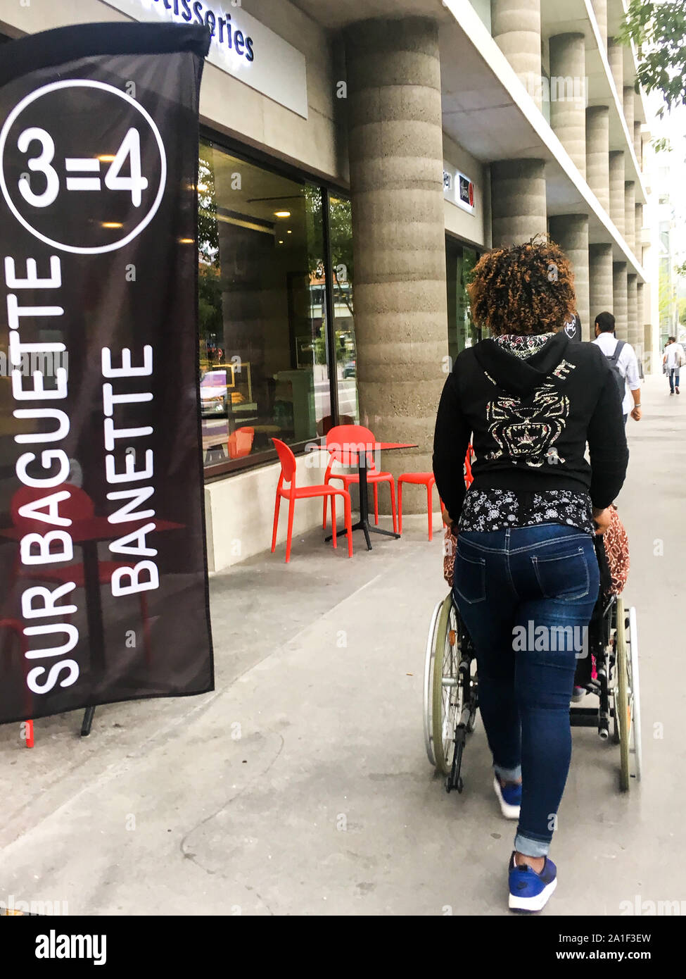 A human person helper pushes a wheelchair in a street, Lyon, France ...