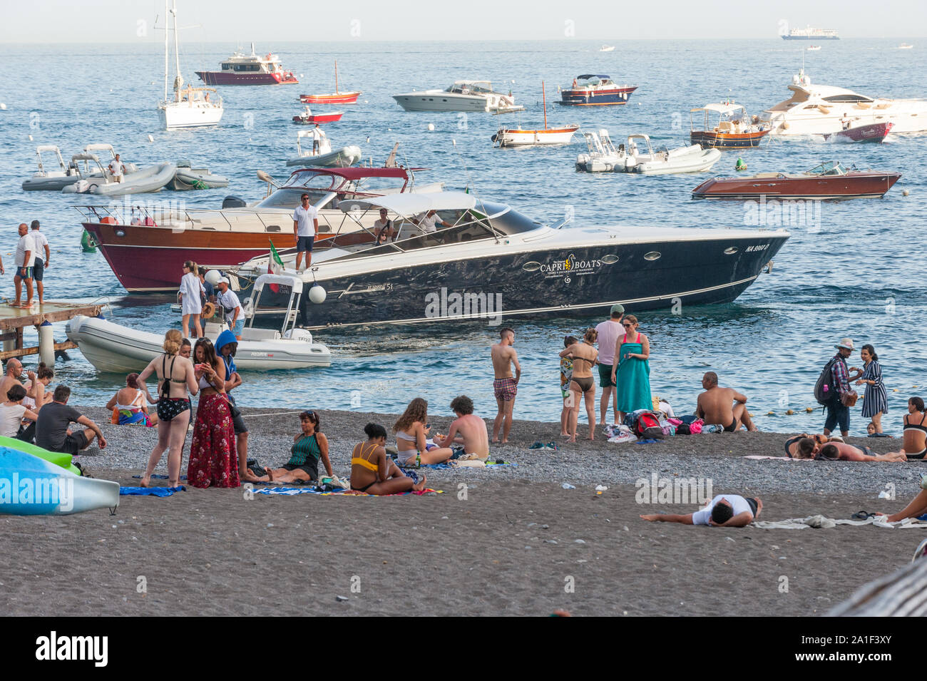 Positano crowded beach with lot of boats Stock Photo - Alamy