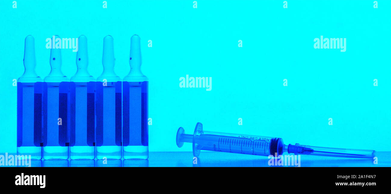ampoules with a solution for injection and a disposable syringe on a ...