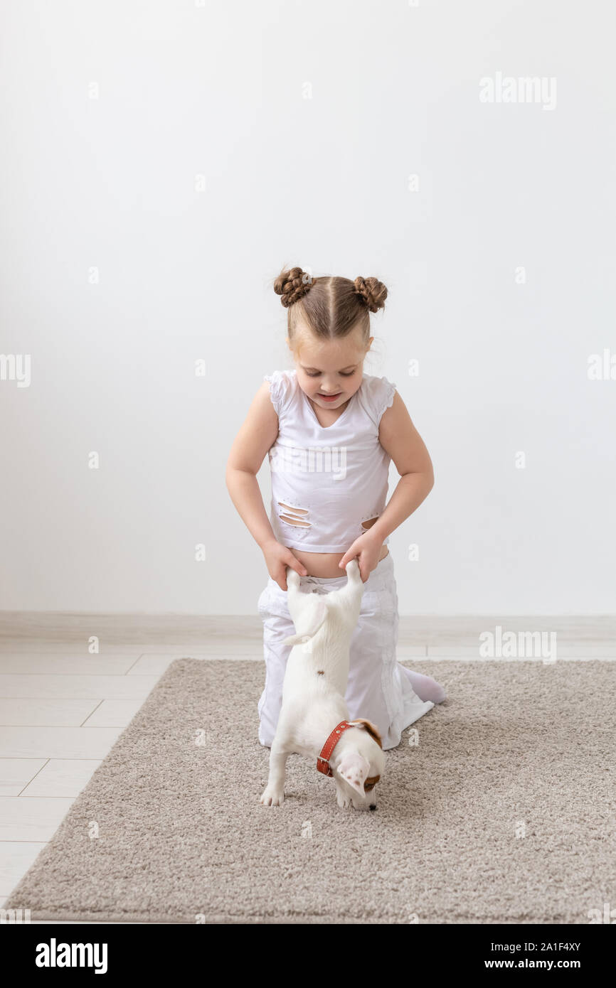 Pet, children and animal concept - Adorable child girl and funny puppy ...