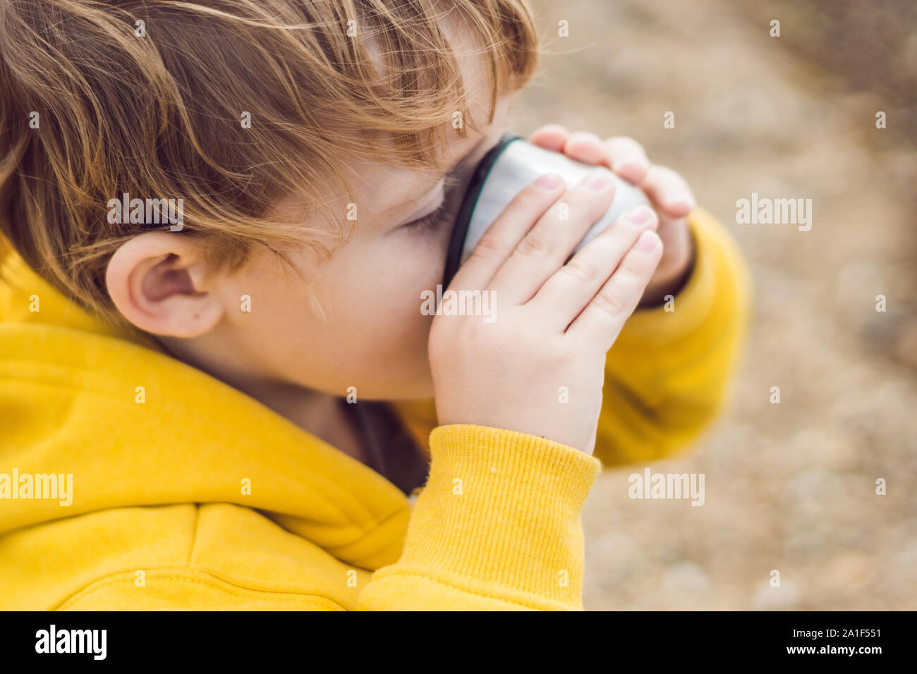 Portrait of Adorable cute boy resting and drinking tea from a thermos ...