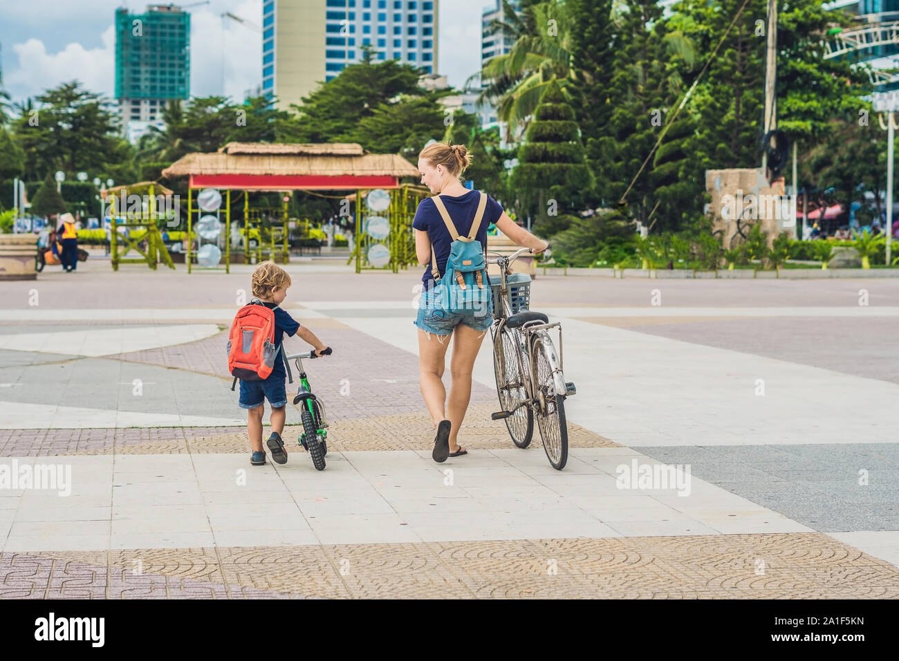 Happy family is riding bikes outdoors and smiling. Mom on a bike and ...