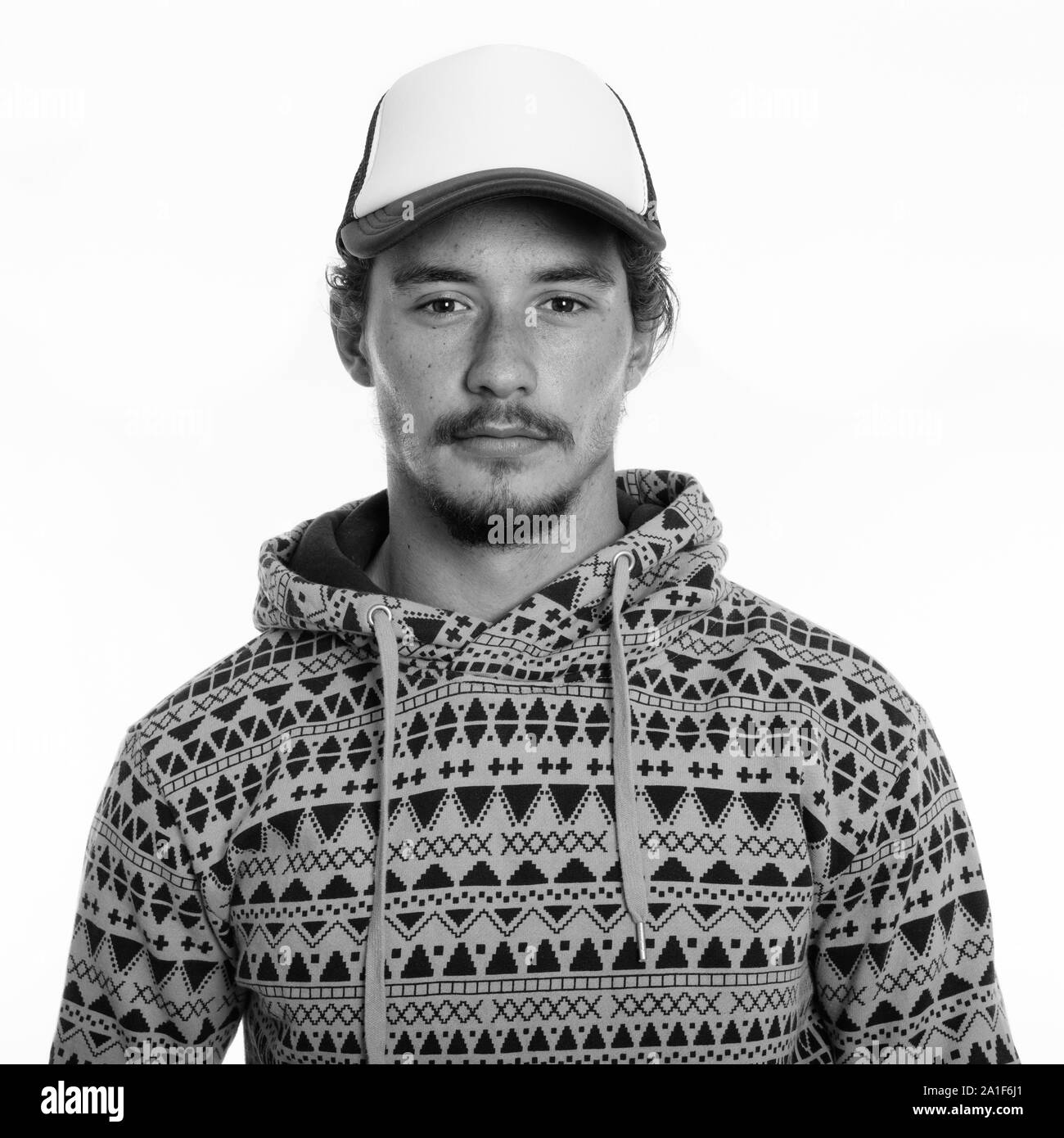 Studio shot of young handsome man wearing cap isolated against white ...