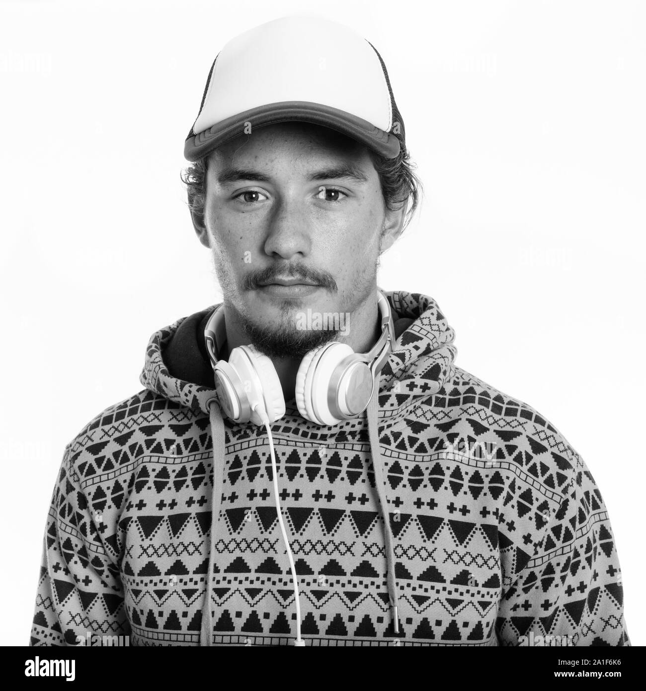 Studio shot of young handsome man wearing cap and headphones around ...