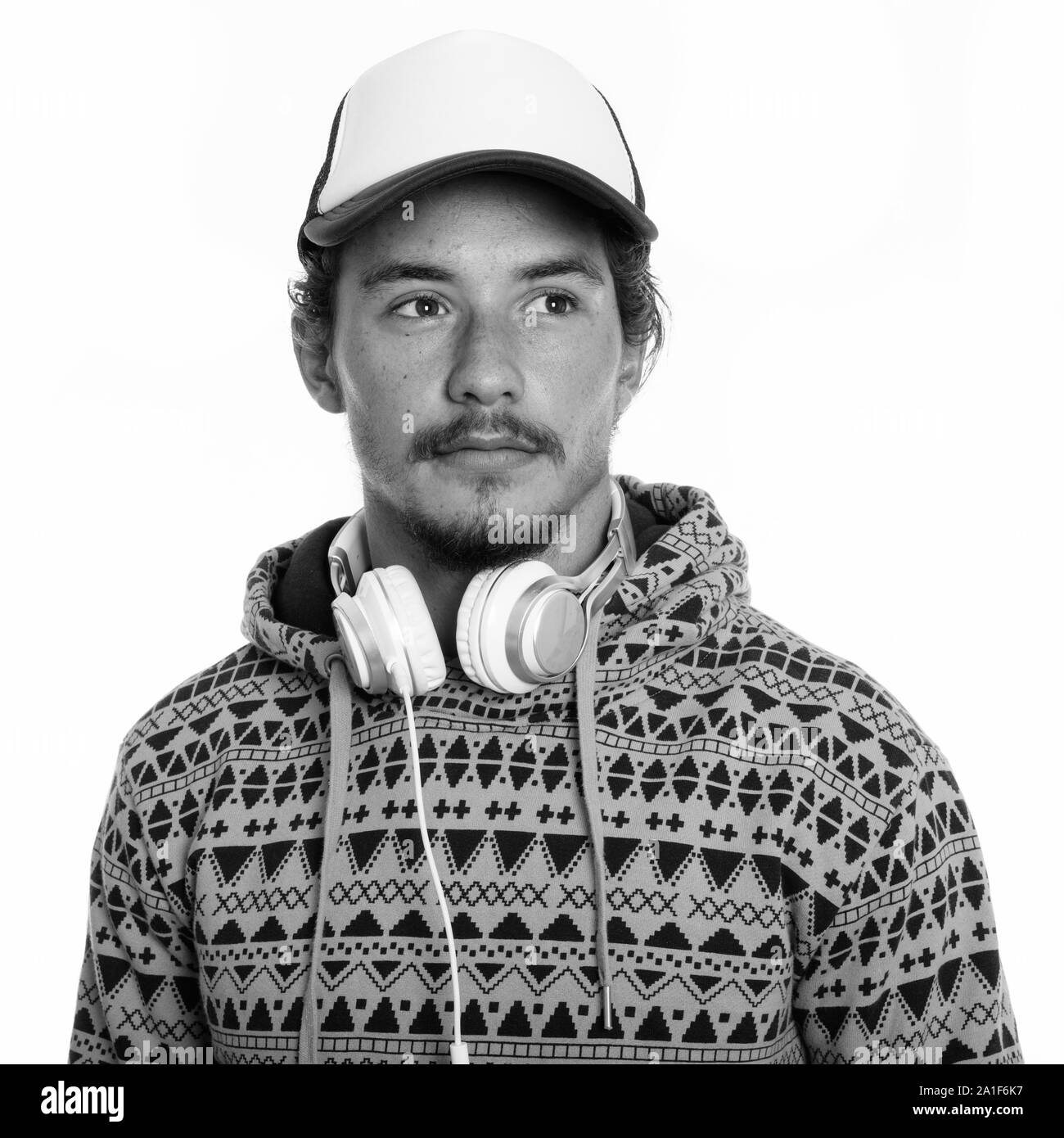 Studio shot of young handsome man thinking while wearing cap and ...