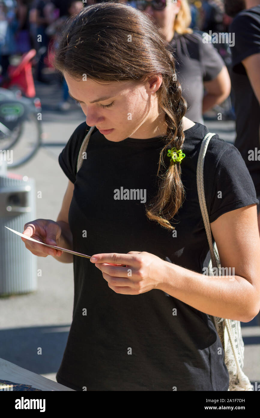 Female customer reading leaflet at outdoor market Stock Photo - Alamy