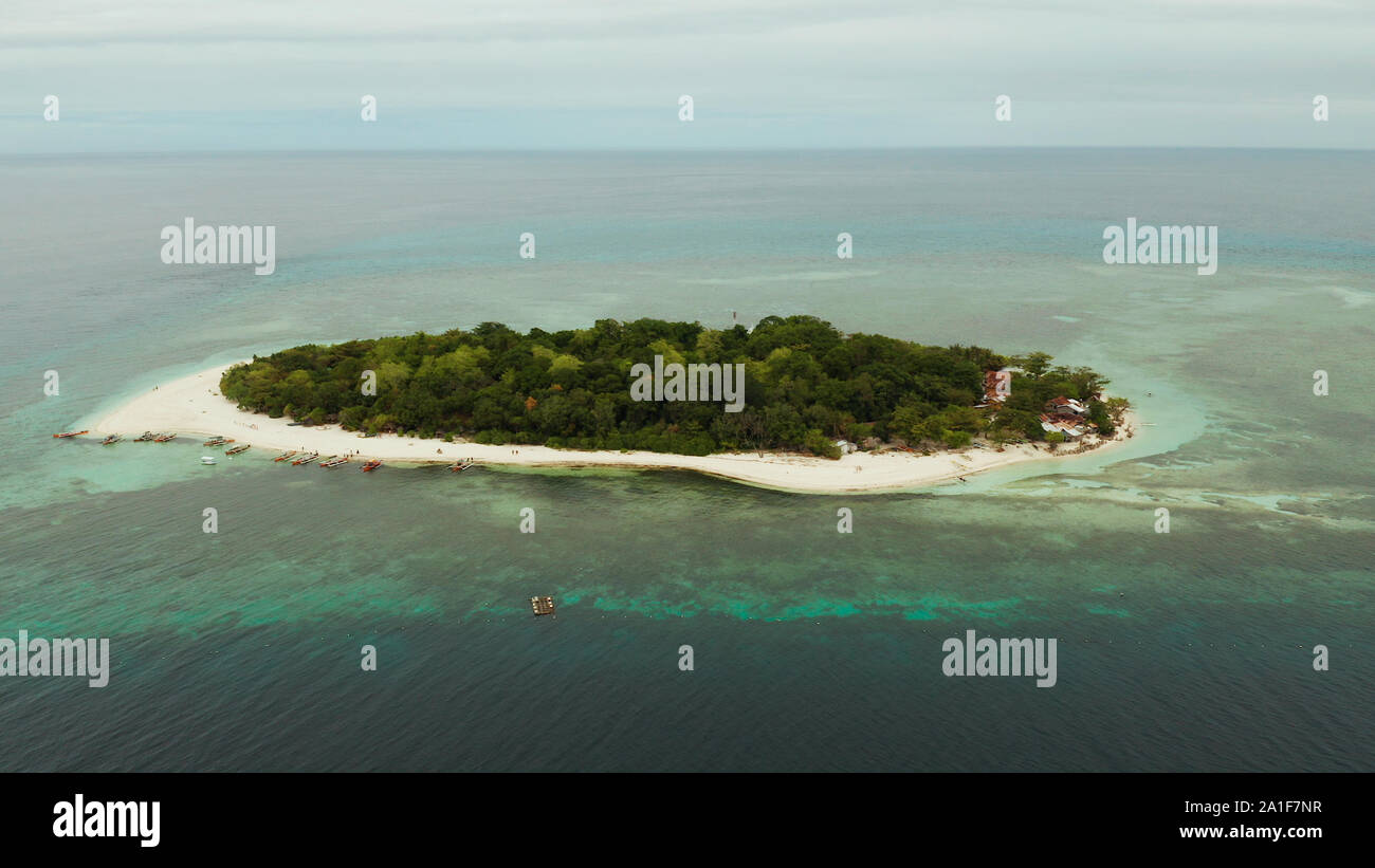 Tropical island Mantigue and sandy beach surrounded by atoll coral reef ...