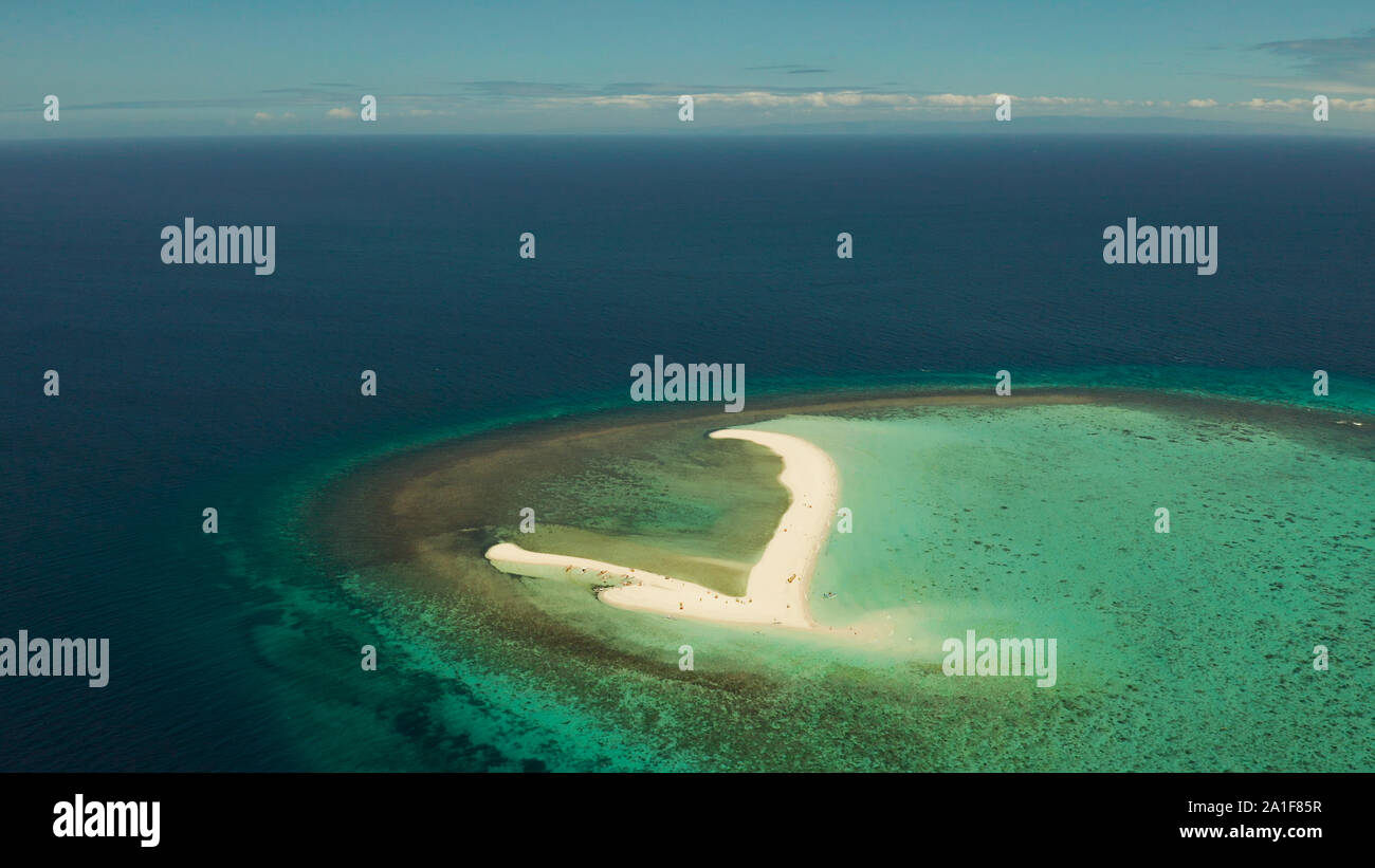 Tropical white island and sandy beach with tourists surrounded by coral ...
