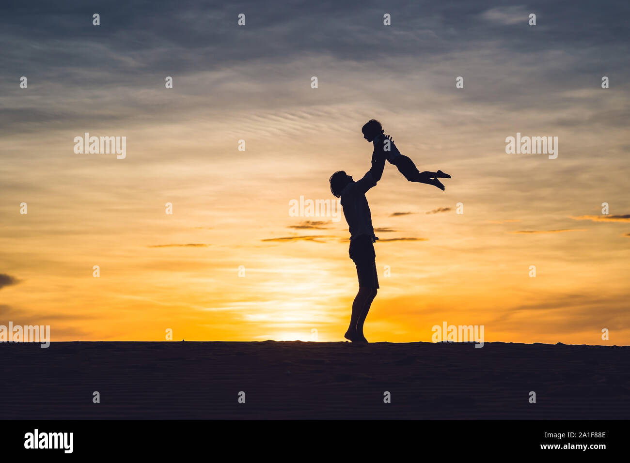 Father and son at the red desert at dawn. Traveling with children ...