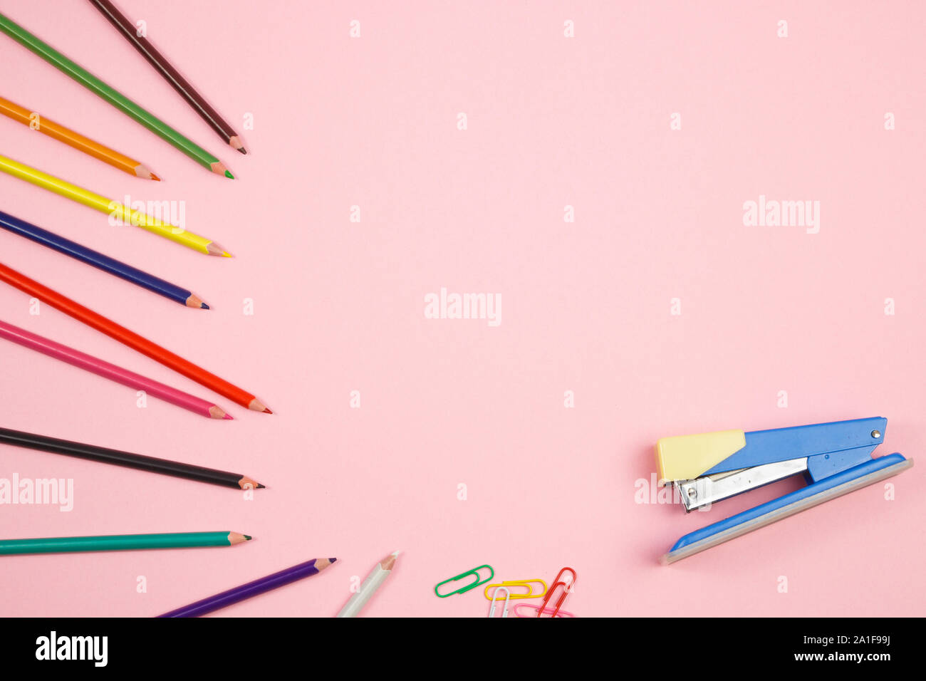 colored pencils and stationery on pink isolated background. top view ...