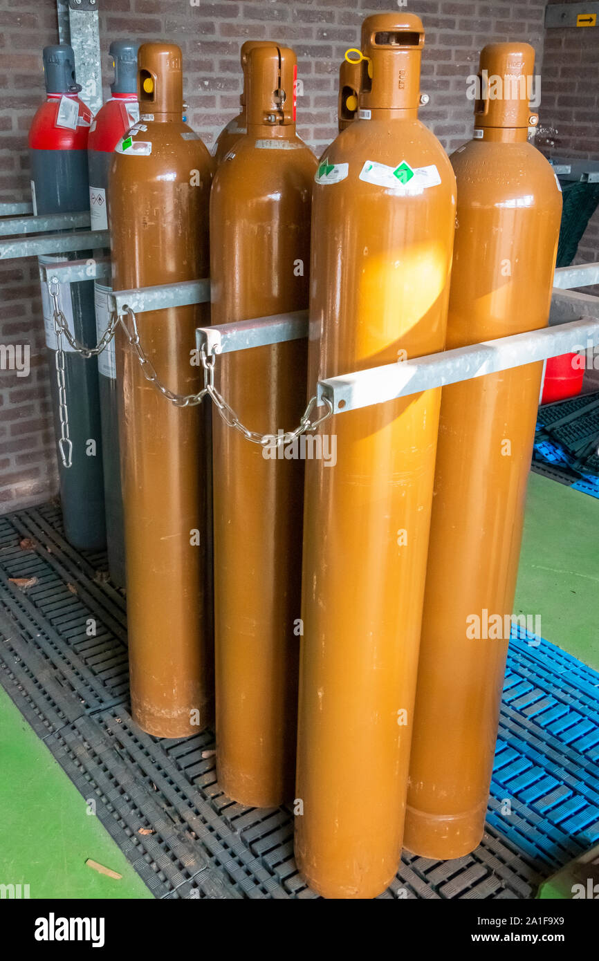 Industrial gas bottle storage, hooked and chained for safety reasons ...