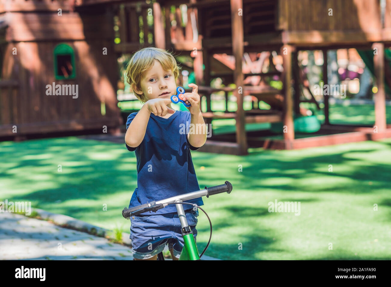 Boy playing with fidget spinner. Child spinning spinner on the ...