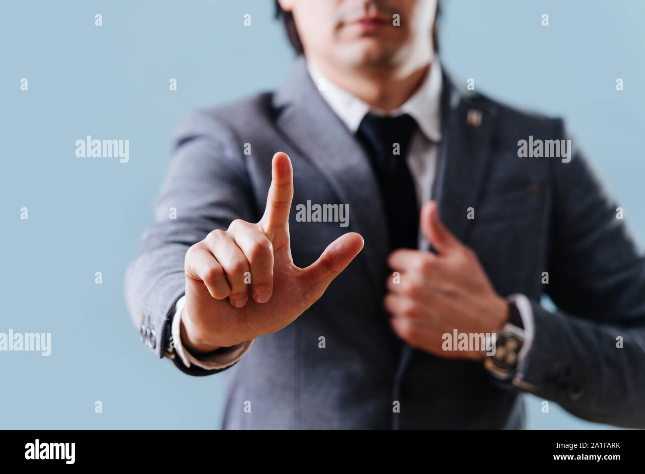 Businessman in suit making objection gesture , holding index finger up ...