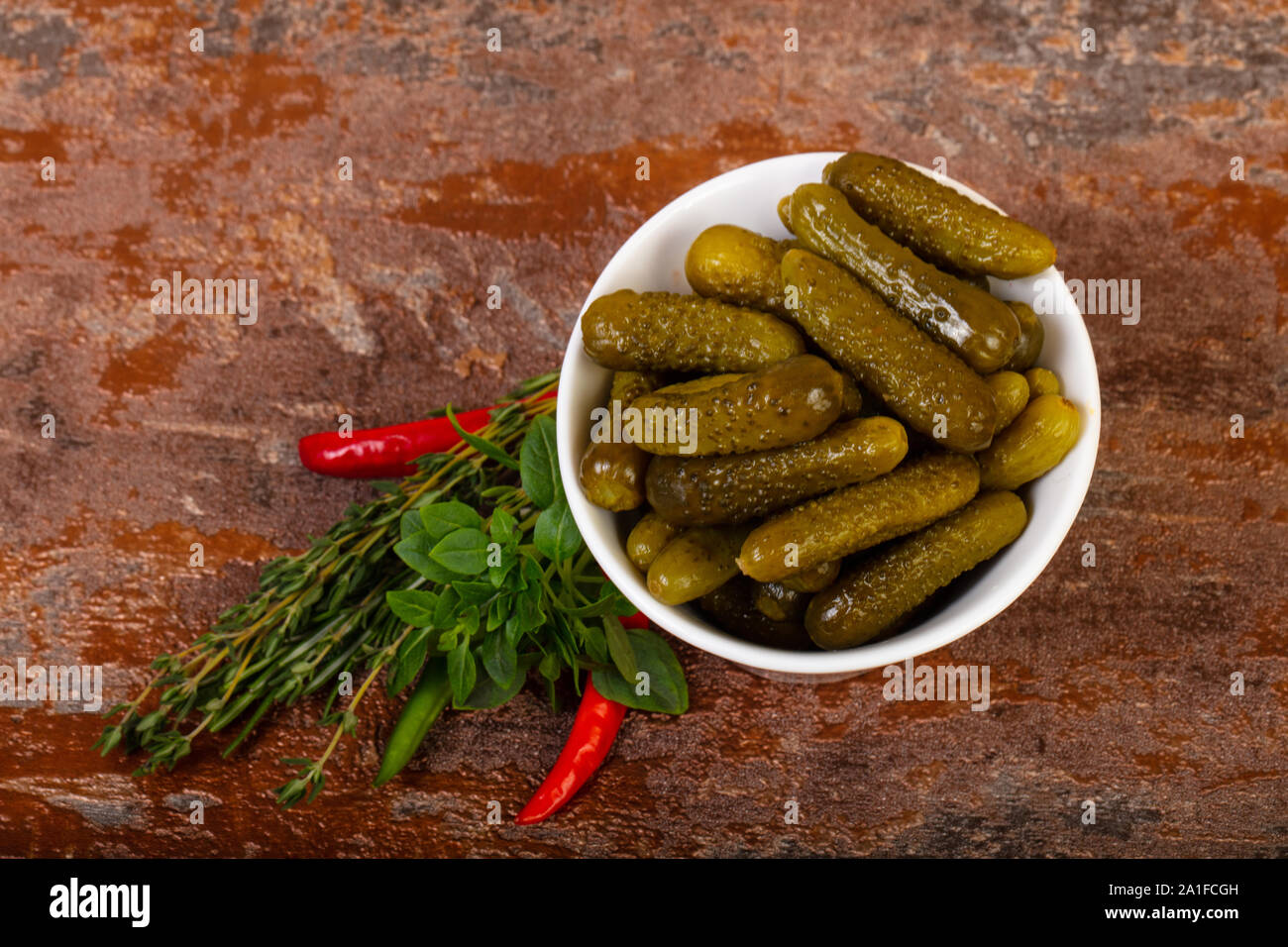 Pickled small cucumbers in the bowl served herbs Stock Photo - Alamy
