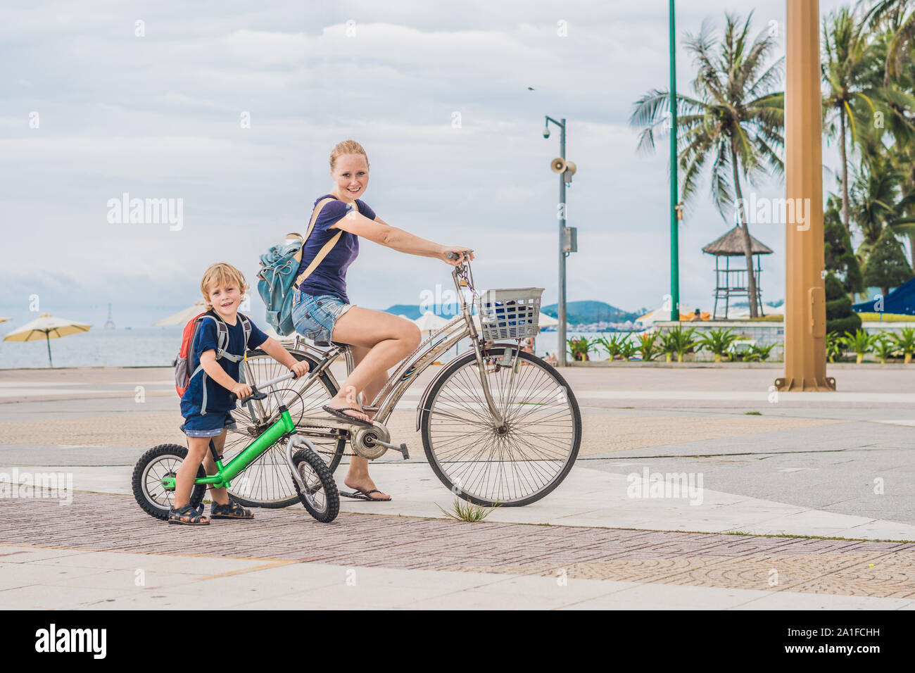 Happy family is riding bikes outdoors and smiling. Mom on a bike and ...