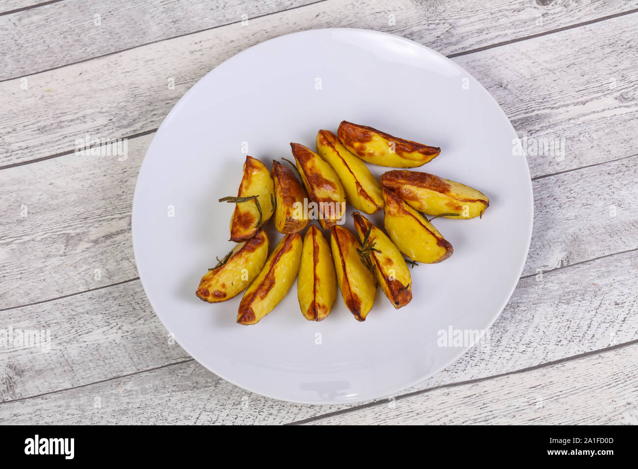 Baked potato pieces with rosemary Stock Photo - Alamy