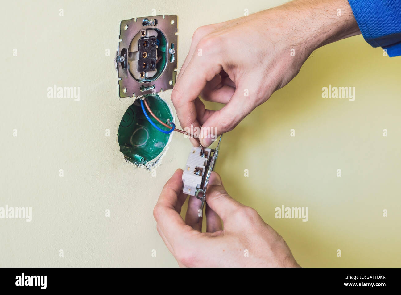 Electrician Installing Socket In New House. Electrician in the house ...