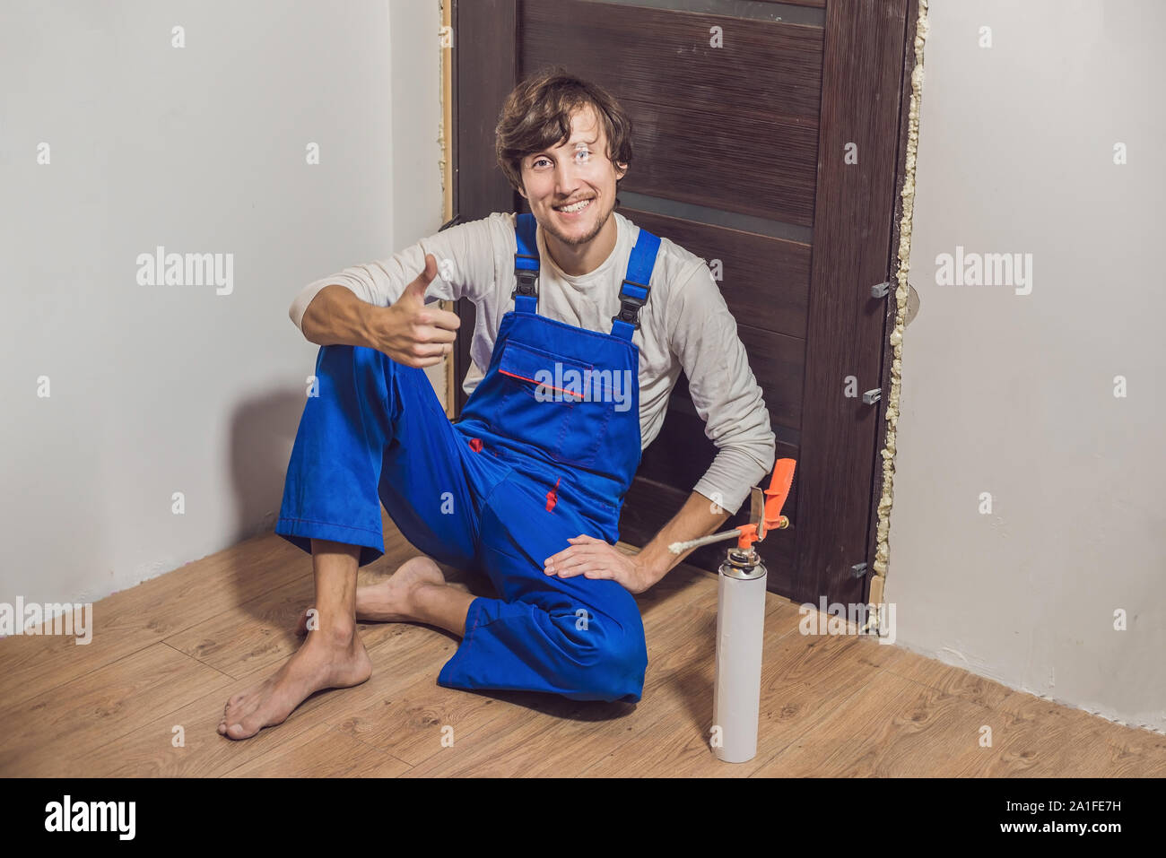 Young handyman installing door with an mounting foam in a room Stock ...