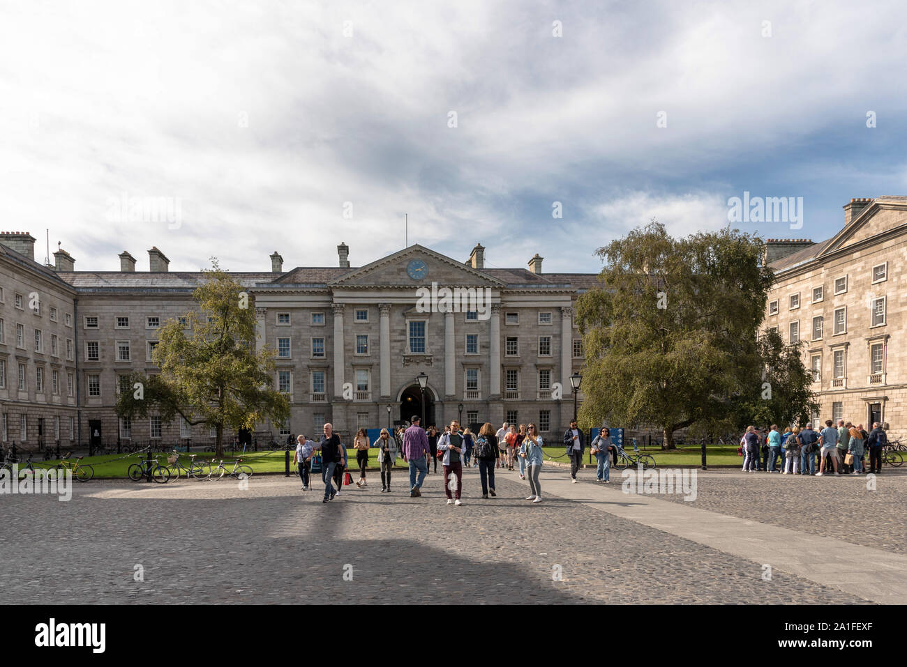 People on Parliament Square at Trinity College Dublin with Regent House in the background on a ...