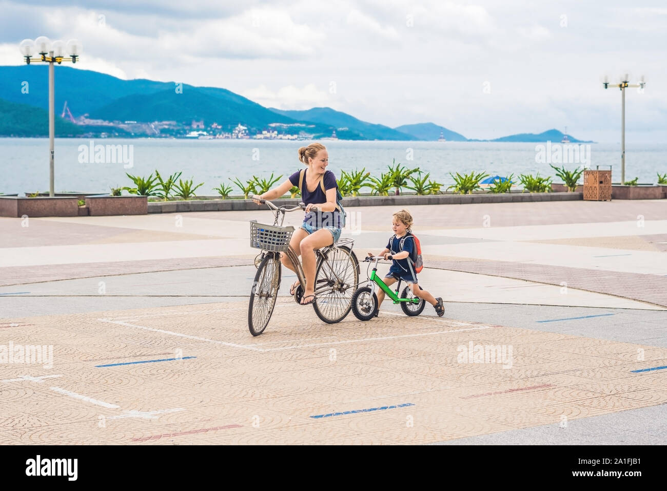 Happy family is riding bikes outdoors and smiling. Mom on a bike and ...