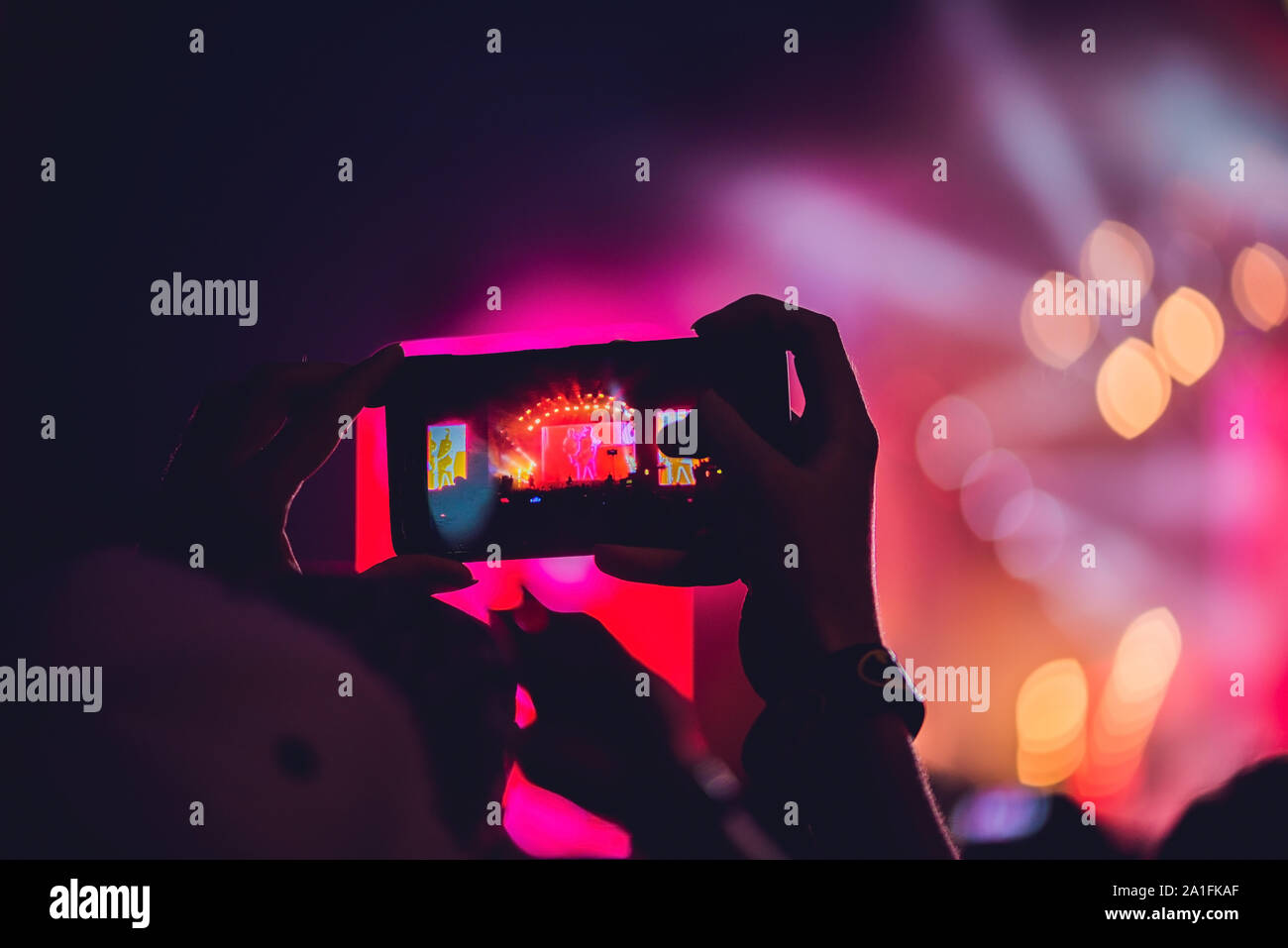 People enjoying rock concert and taking photos with cell phone at music ...