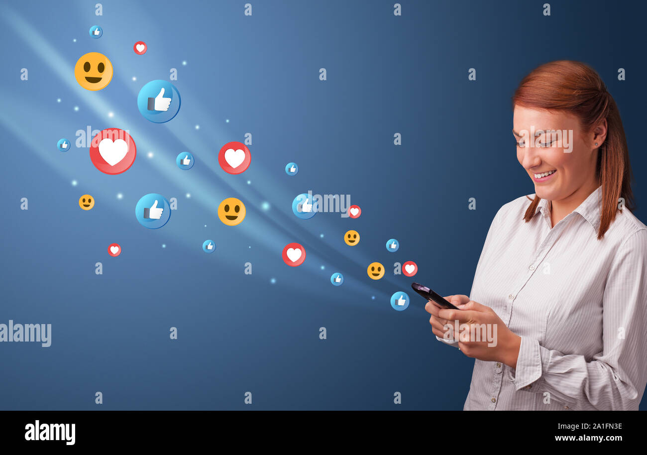Young person using smartphone with flying social media icons around ...