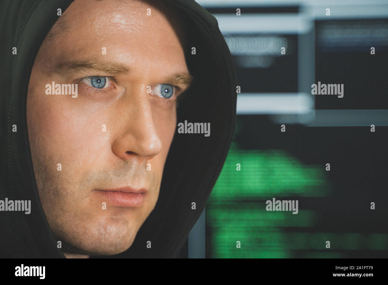 Handsome hacker in black hoodie. Hacking and internet security concept ...