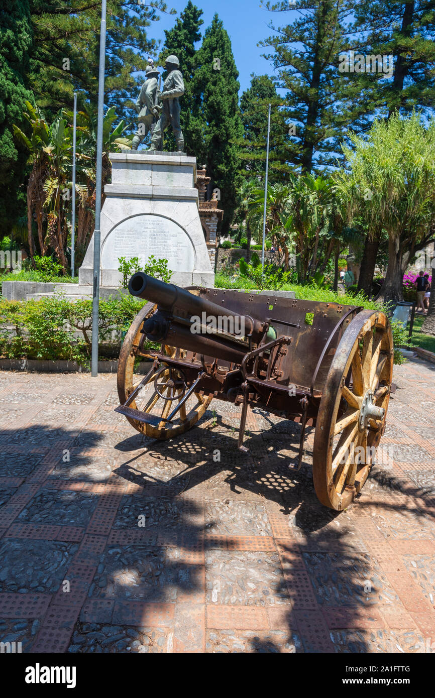 A cannon weapon in front of monument of italian soldiers of World War ...