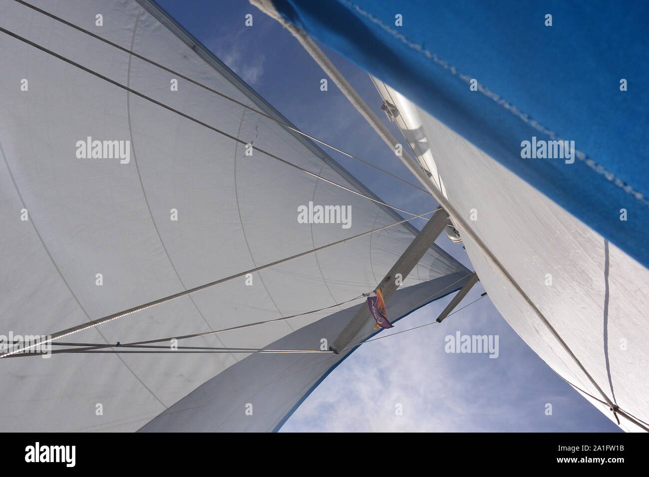White & Blue sails of a sailing yacht in the wind. Mast and rigging on ...