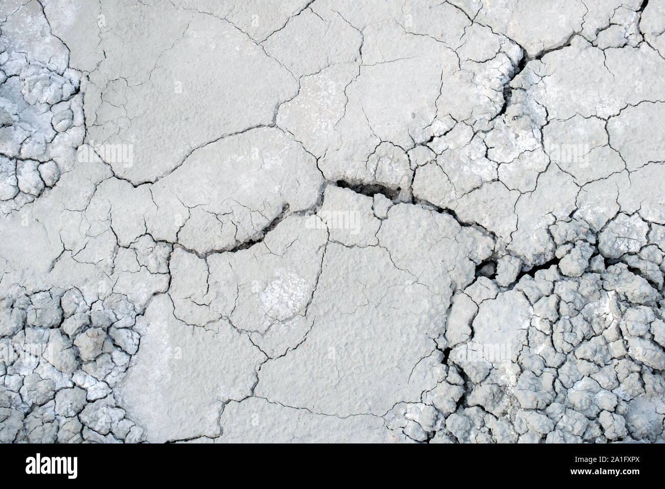 Dried ground with cracks. Grey land us a symbol ecological catastrophe ...