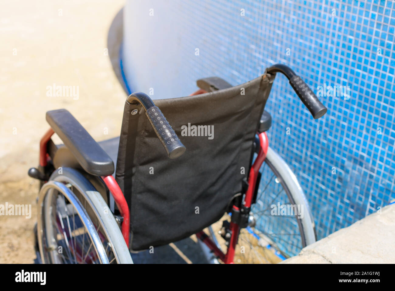 Empty wheelchair on an accessible beach with pool for assistance to ...