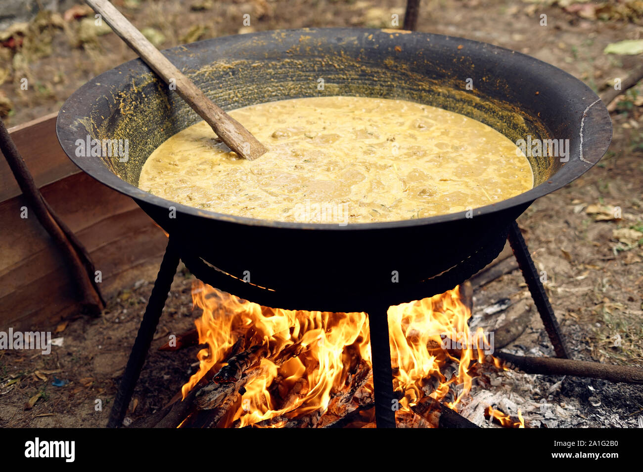 Cooking Traditional Meat Curry in a large pan on a wood fire Stock ...