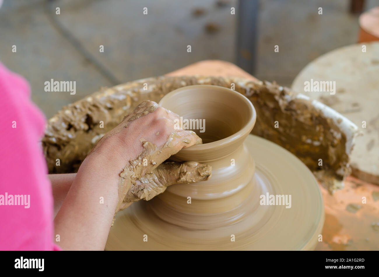 Ceramic working process with clay potter's wheel, close up. The woman ...
