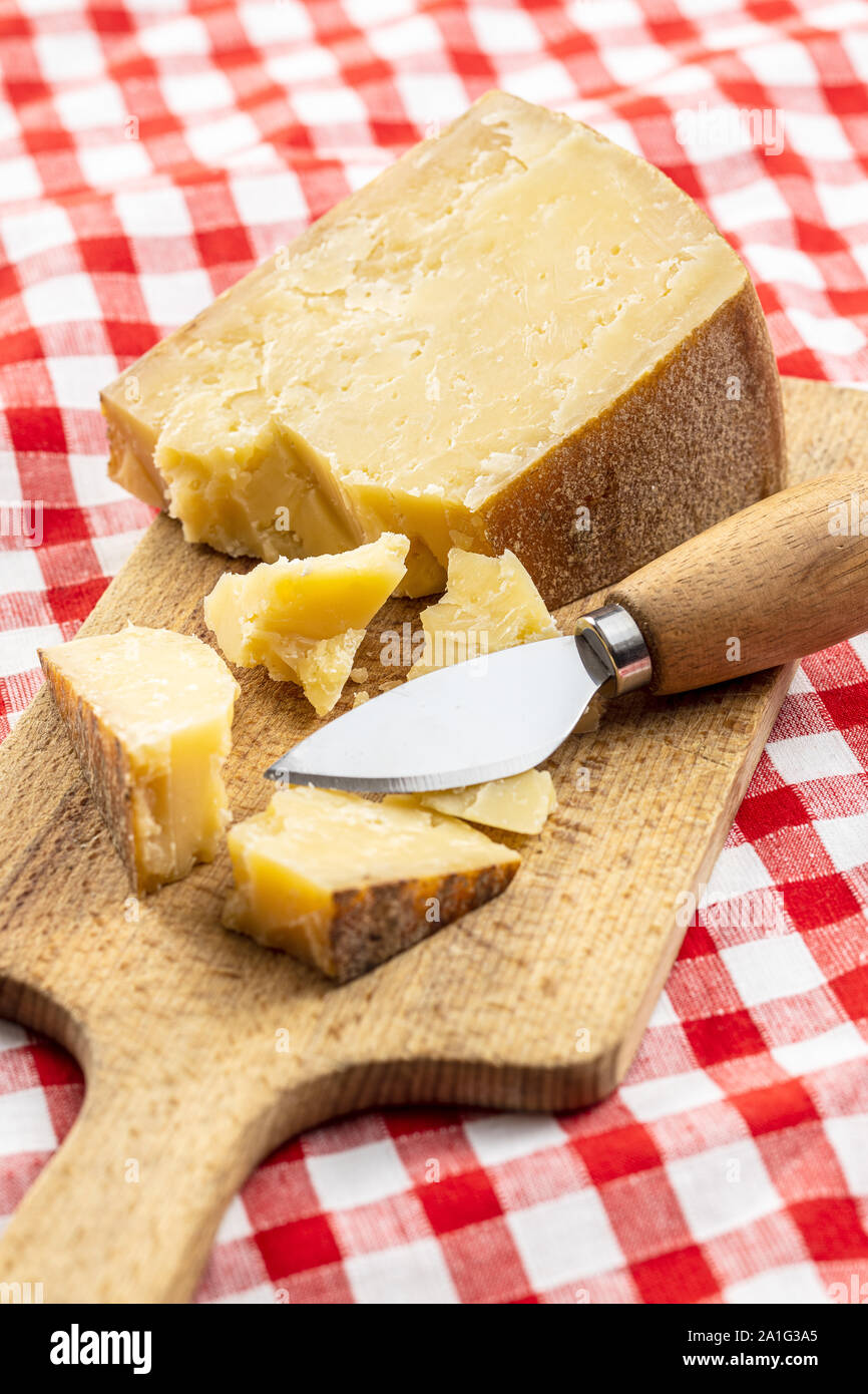 Crushed block of cheese with cheese knife on cutting board Stock Photo ...