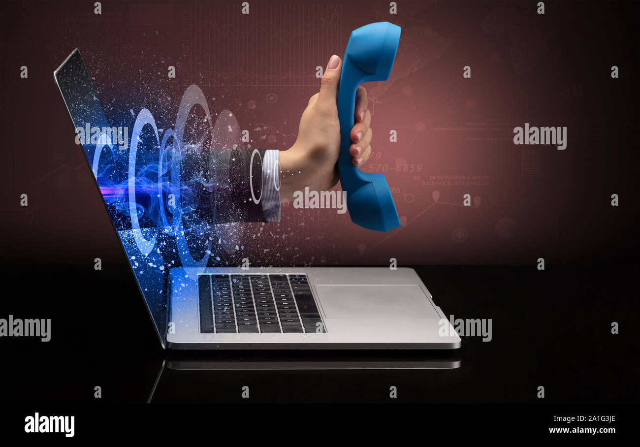 Hand with vintage phone coming out of a laptop with sparkling effects ...