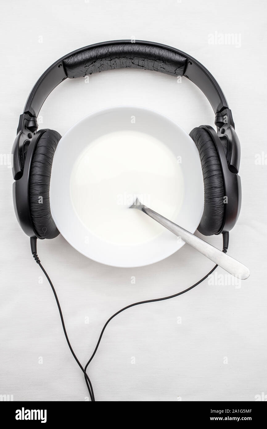wearing headphones on a plate with a spoon position inside, symbolizing ...