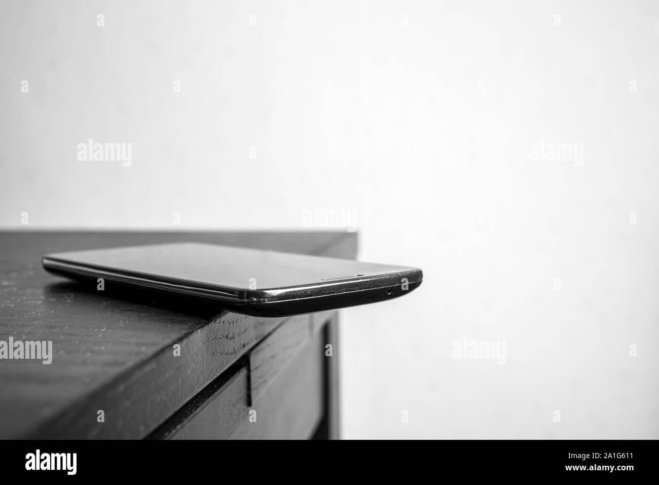 mobile phone is dangerous lies on the edge of the table, carelessly ...