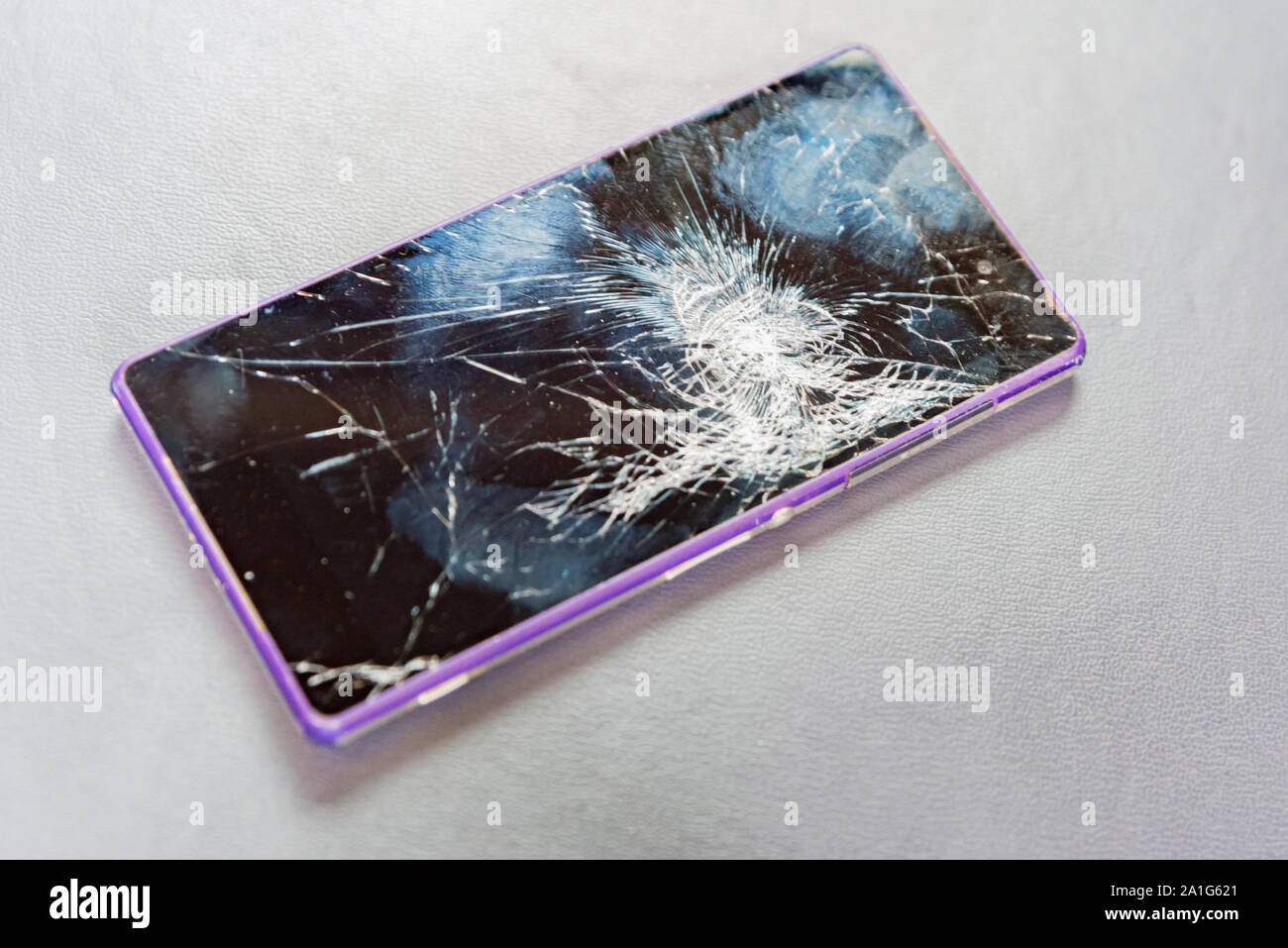 Close up purple mobile phone with broken glass Stock Photo - Alamy