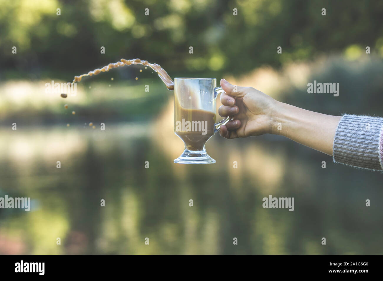 A conceptual photo of a person's hand causing a spill of the coffee ...