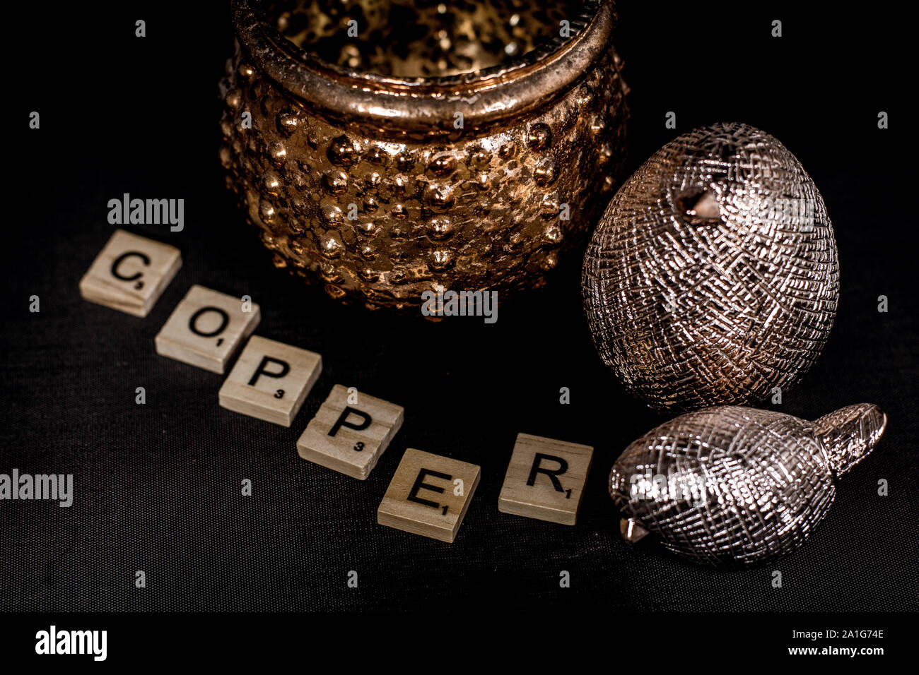 2 copper decor birds and a small candle pot in coppery colors with the ...