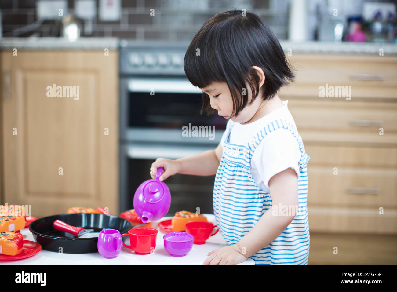 toddler baby girl pretend play food preparing Stock Photo - Alamy