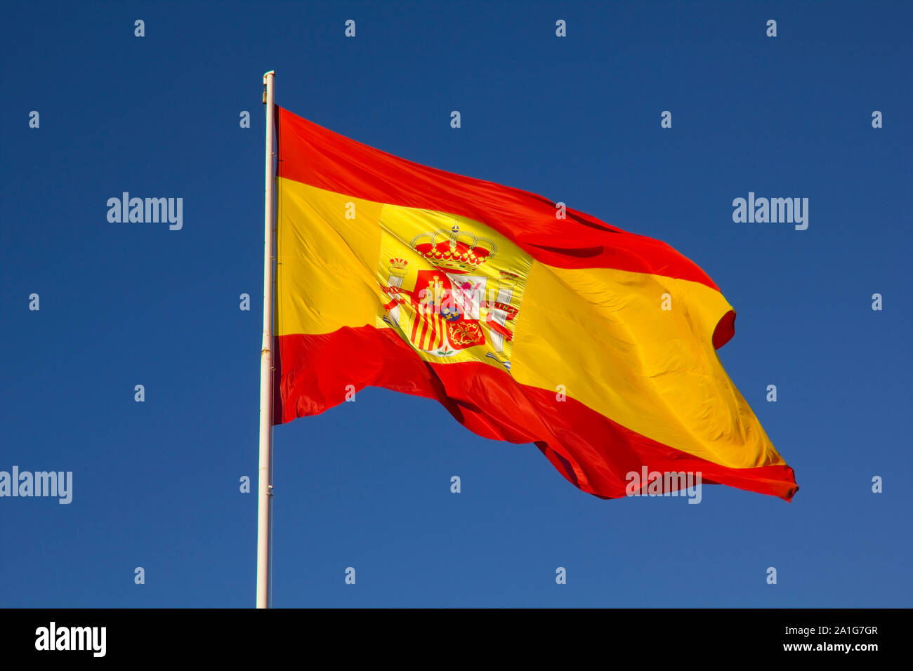 Spanish flag on a pole, undulating in the wind Stock Photo - Alamy