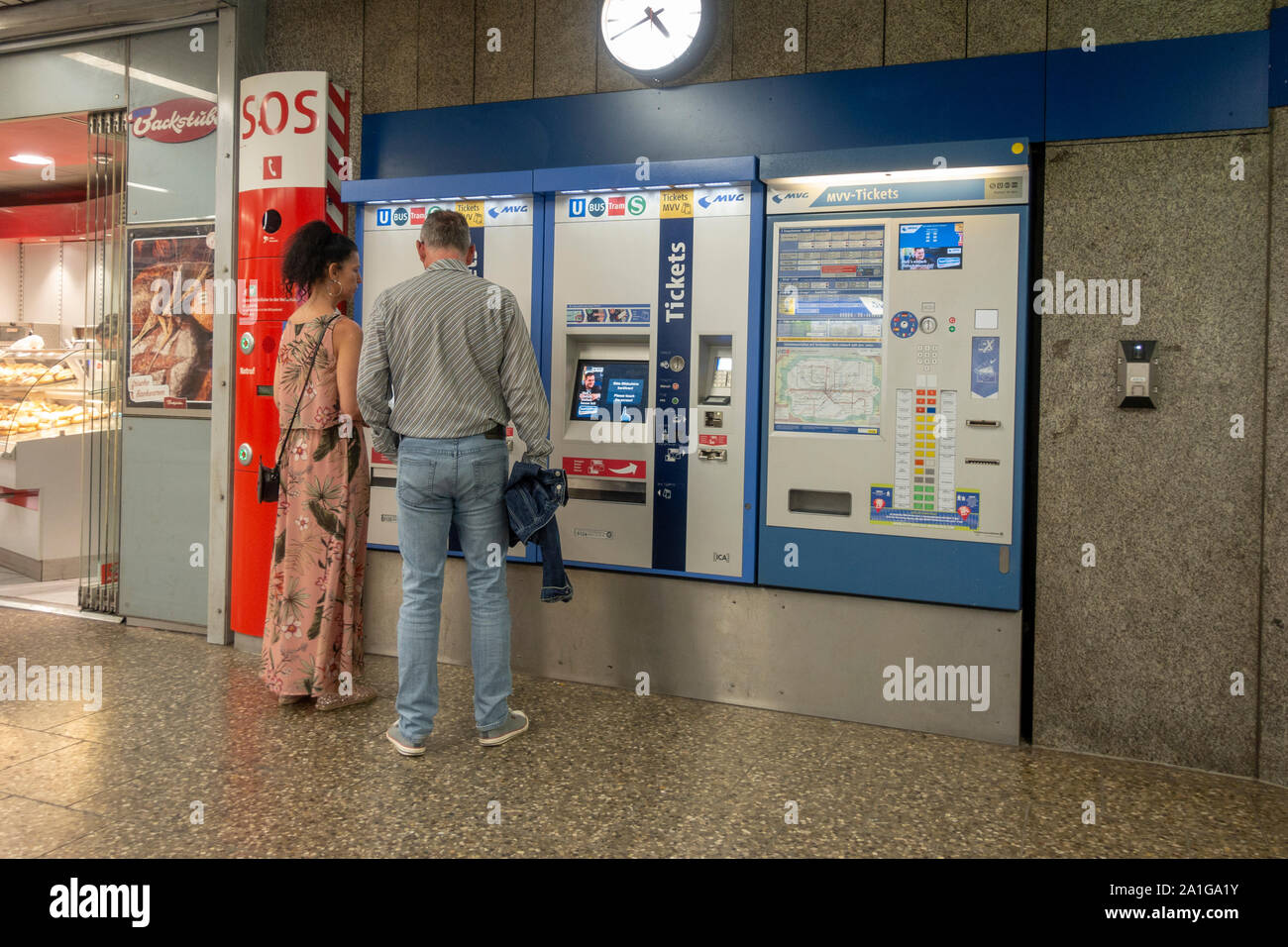 Passeners to the Munich underground using a ticket machine in Munich ...