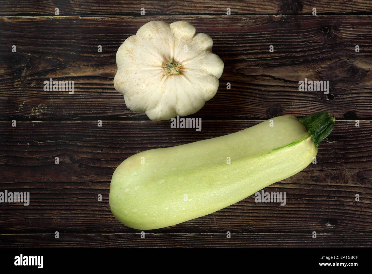 Pattypan squash and light green courgette on dark wooden board, view ...