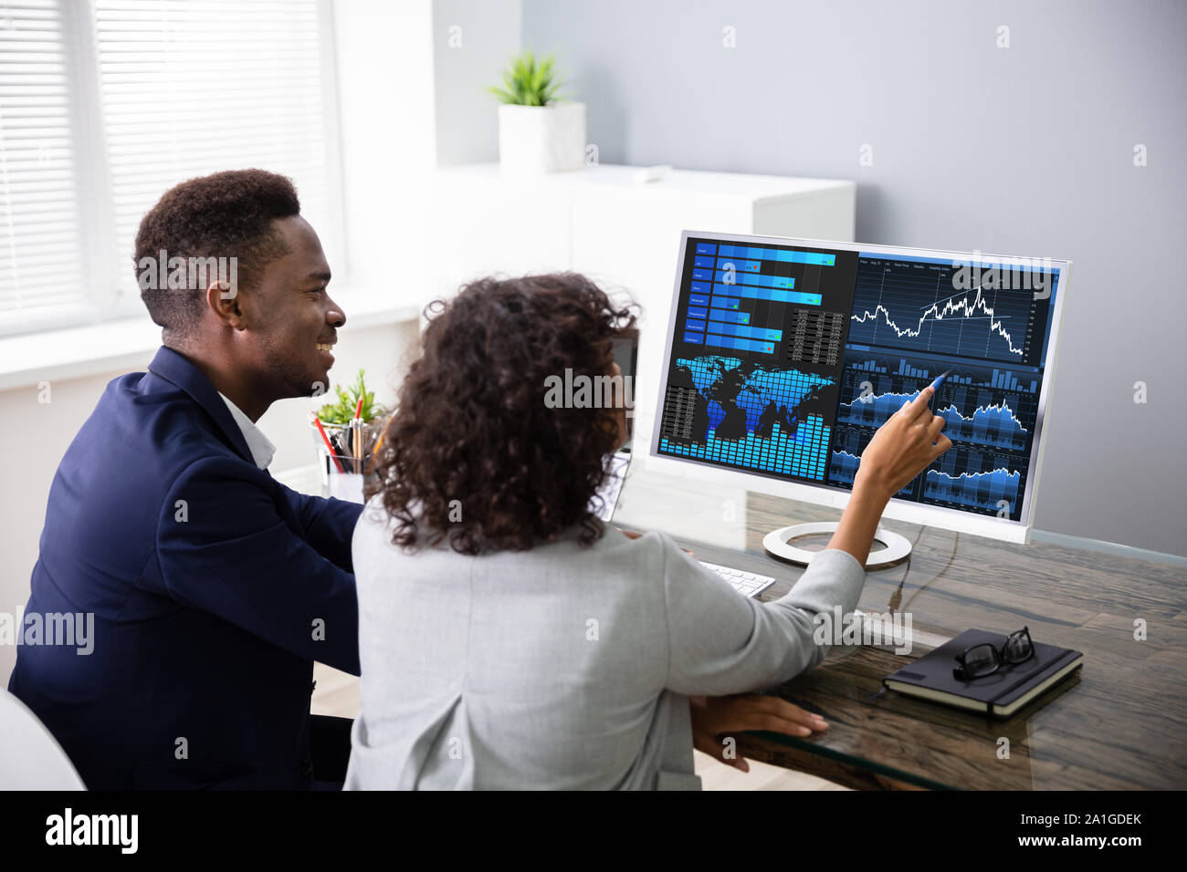 Stock Market Broker Analyzing Graphs On Computer In Office Stock Photo ...