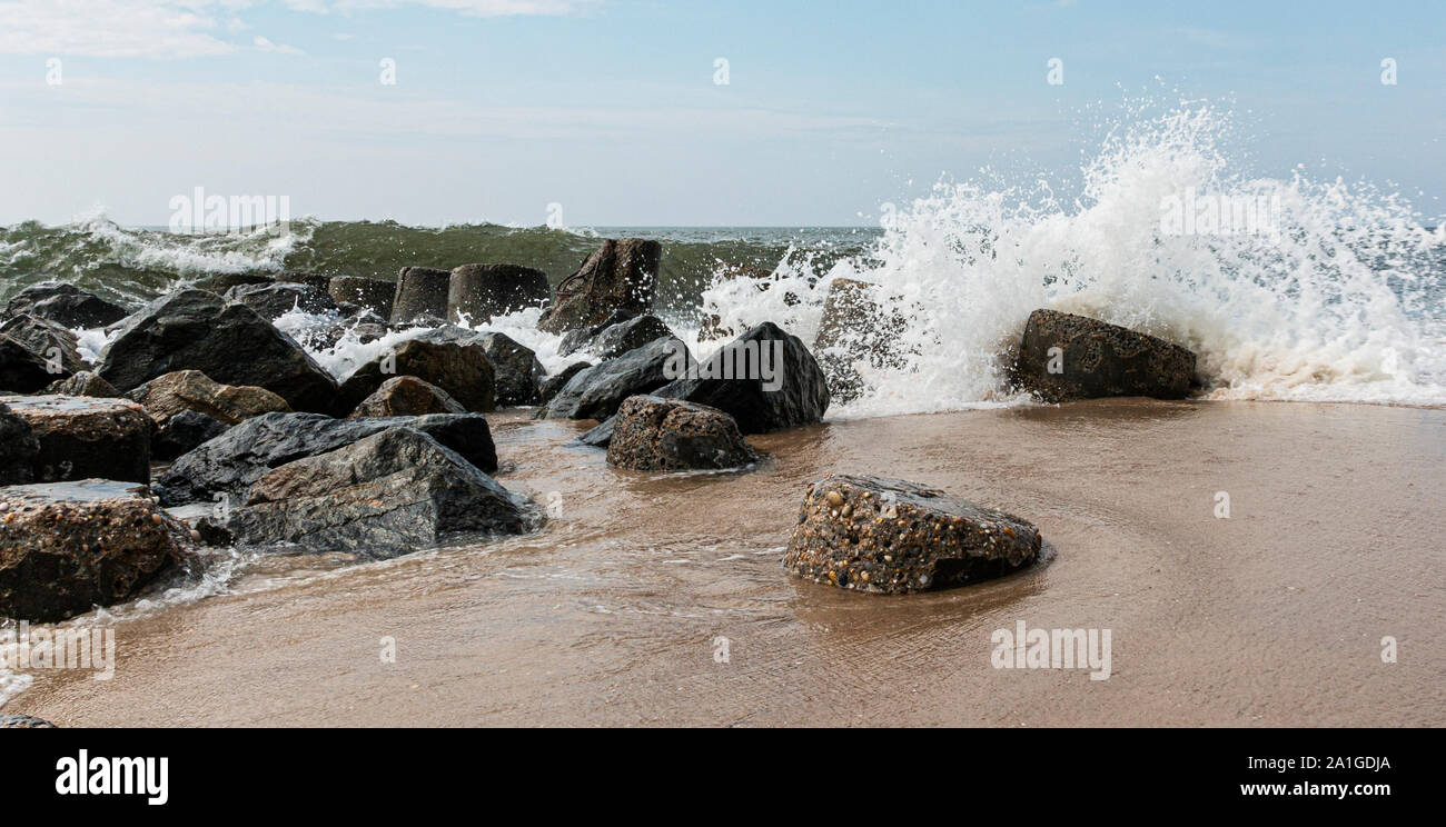 Atlantic Ocean waves are crashing into a stone jetty on the shore of ...