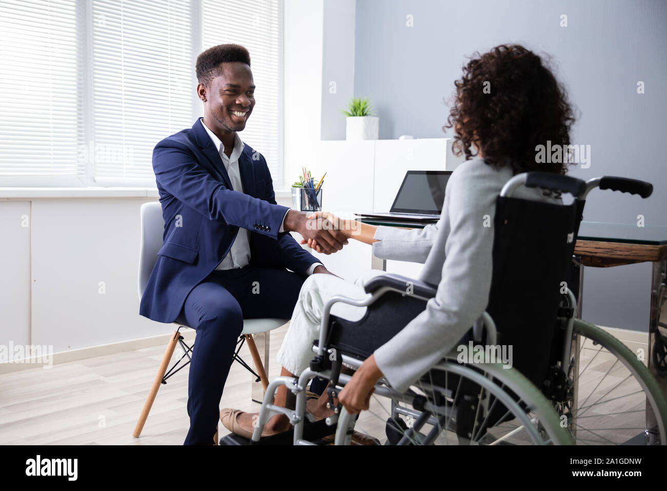 Businesswoman shaking hands disabled businessman hi-res stock ...